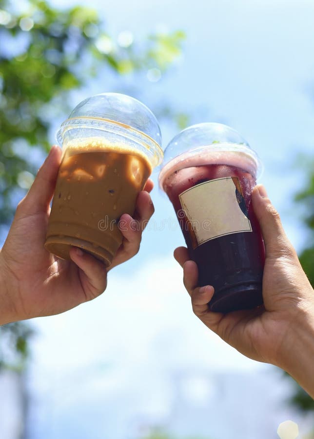 Hand Clinking Plastic Cups of Coffee and Mulberry Tea Closeup Stock ...
