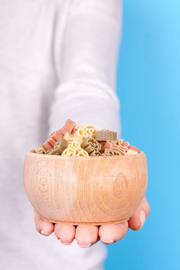 Hand with Colored Pasta in Wooden Jar on Blue Background Stock Photo ...