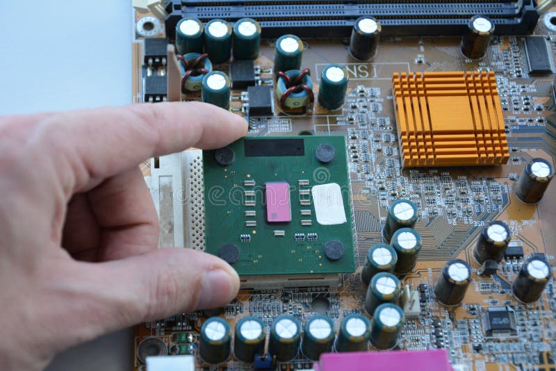 Engineer Technician Holds in His Hand with the Tweezers CPU Microprocessor and Plug in Computer ...
