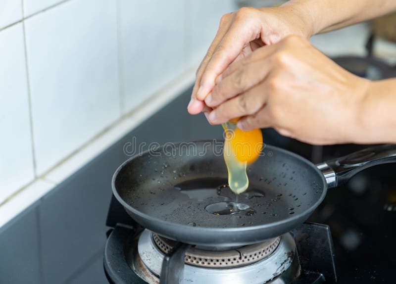Hand Crack an Egg on Frying Pan in the Kitchen Stock Photo - Image of ...