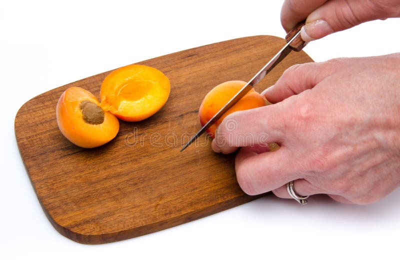 Hand Cutting an Apricot in Half Stock Photo - Image of knife, food ...