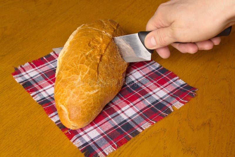 Hand Cutting a Loaf of Wheat Bread. Stock Photo - Image of bakery ...