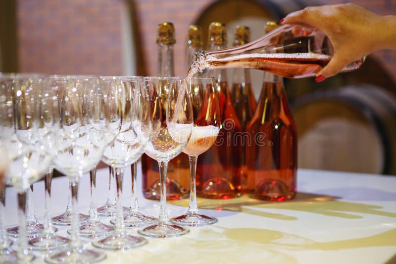 Elegant Evening of Tasting with Rose Wine Pouring into Crystal Glasses ...