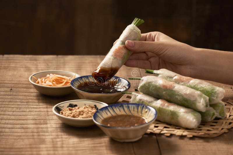 Hand Dipping Vegetarian Rice Paper Rolls into the Soy Sauce Stock Image ...
