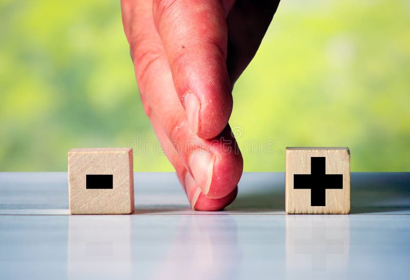 Hand Divides Two Wooden Blocks with the Words Plus and Minus Stock ...