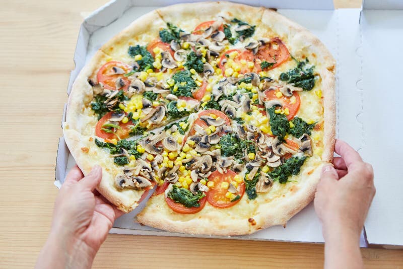 Hand while Dividing Vegetable Pizza with Pizza Slice Stock Photo ...