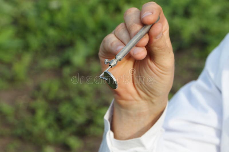 Hand of the Doctor in a White Form Holding a Medical Mirror Stock Photo ...