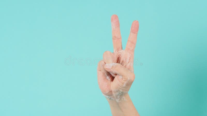 The Hand is Doing the Peace or Good Luck Sign and Has Foam Soap Bubbles ... The Hand is Doing the Peace or Good Luck Sign and Has Foam Soap Bubbles ...