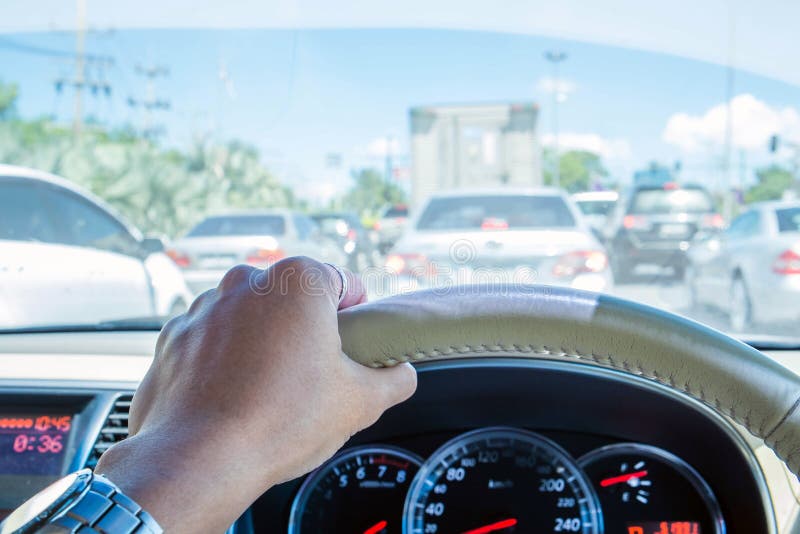 Hand of Driver Holding Steering Wheel, with Traffic View in the City ...
