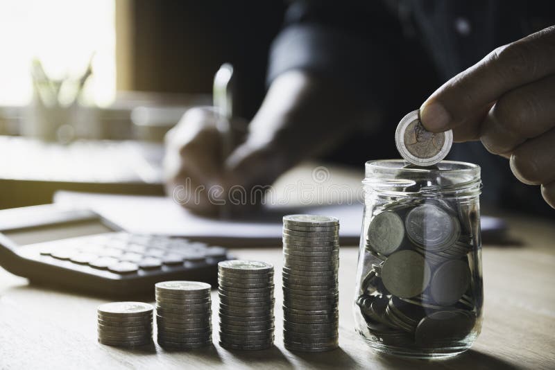 Hand Drop a Coin in Glass Jar with Money Coin Stack Growing for Stock ...