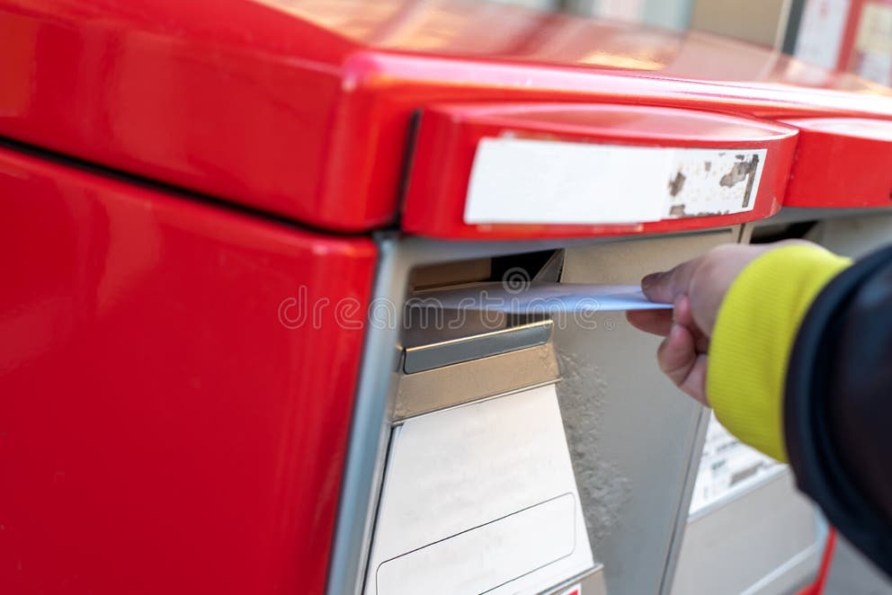 A Hand Dropping Off an Envelope into a Red Post Mail Box Stock Photo ...
