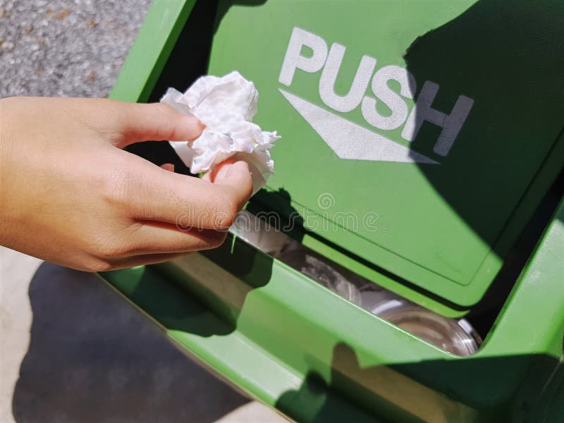 Hand Dropping Tissue Paper into Green Plastic Trash Bin with Push Word ...