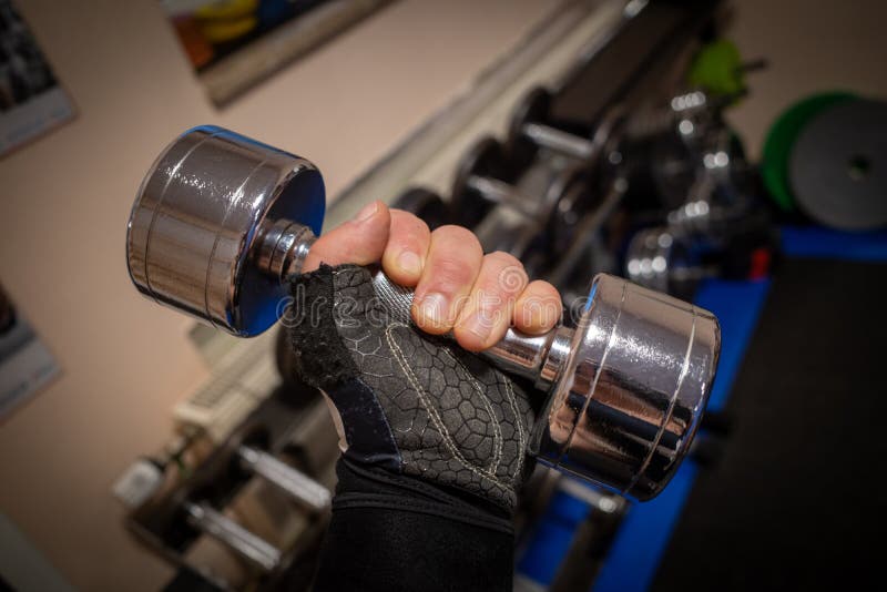 In one hand is a dumbbell stock image. Image of dumbbell - 260908539