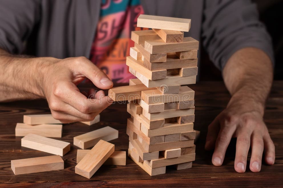 Hand of Engineer Playing a Blocks Wood Tower Game on Blueprint or ...