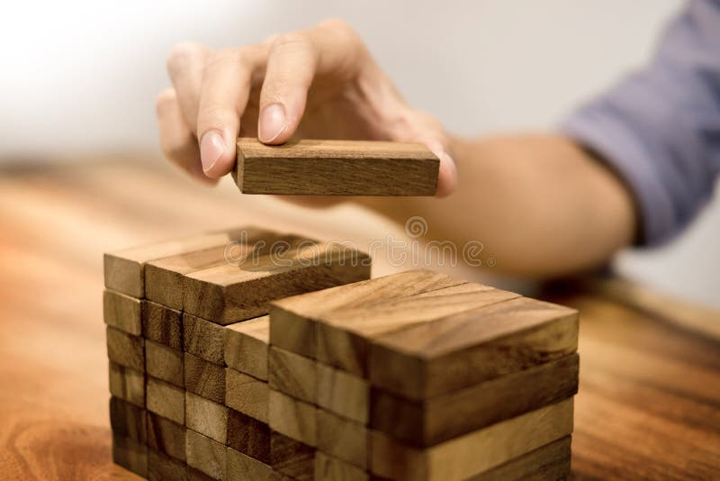 Hand of Engineer Playing a Blocks Wood Tower Game on Blueprint O Stock ...