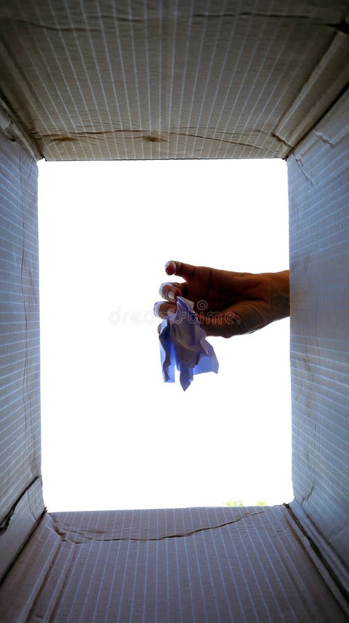 Hand Holding a Piece of Paper Extending from the Inside of a Box ...