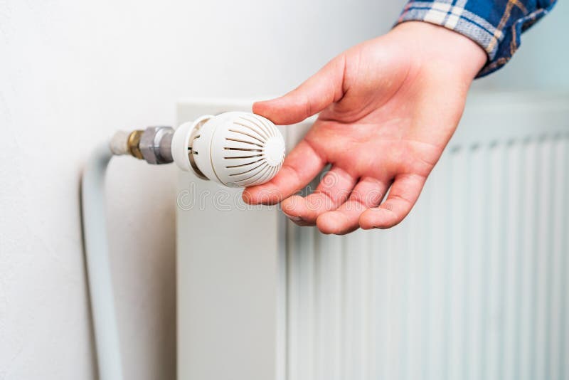 Hand on the Faucet or Temperature Regulator on the Radiator of the ...