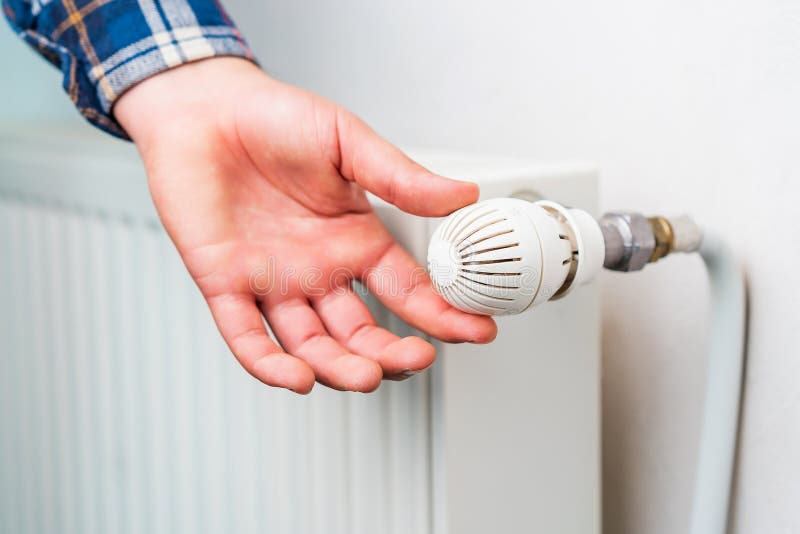 Hand on the Faucet or Temperature Regulator on the Radiator of the ...