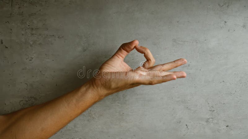 Hand Forming an Okay Gesture Against a Grey Concrete Background ...