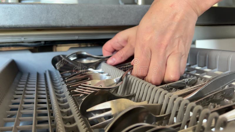 Hand Getting Silverware from Dishwasher Tray in Modern Kitchen Stock ...