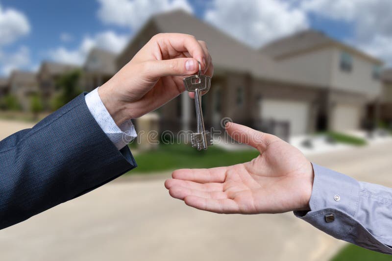 A Hand Giving a Key To Another Hand. House in the Background. Stock ...