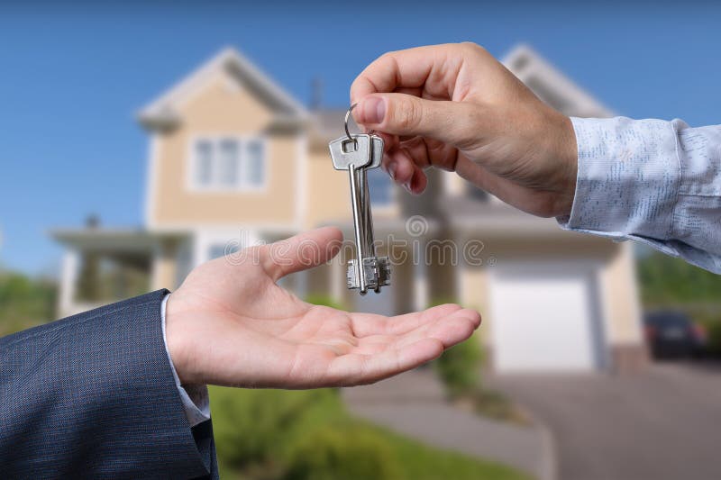 A Hand Giving a Key To Another Hand. House in the Background. Stock ...