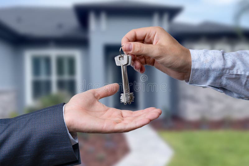 A Hand Giving a Key To Another Hand. House in the Background. Stock ...