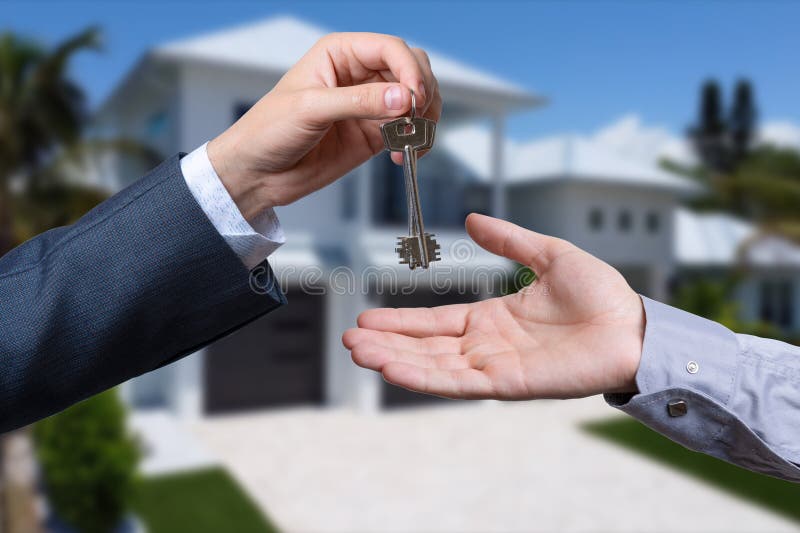 A Hand Giving a Key To Another Hand. House in the Background. Stock ...