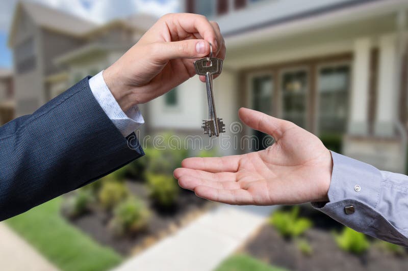 A Hand Giving a Key To Another Hand. House in the Background. Stock ...