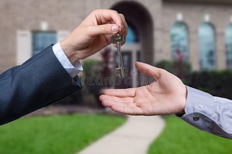A Hand Giving a Key To Another Hand. House in the Background. Stock ...