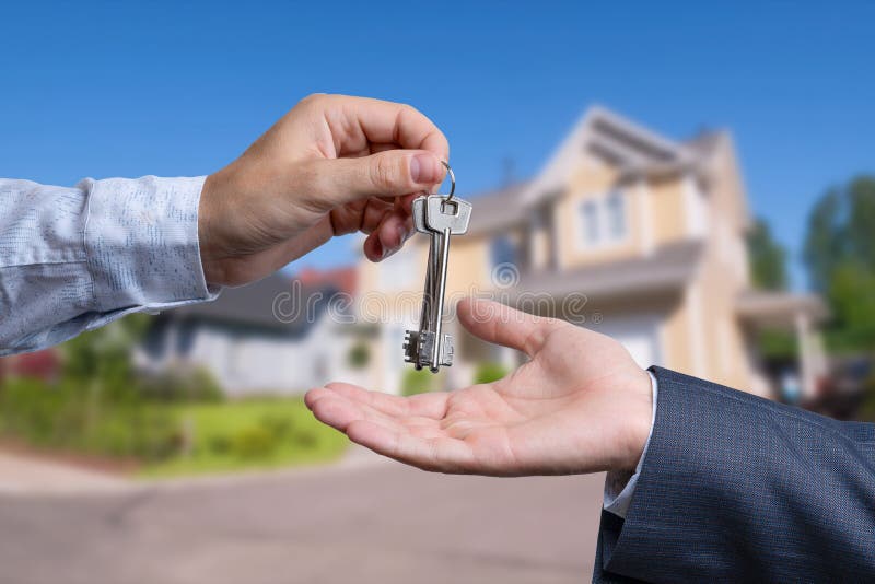A Hand Giving a Key To Another Hand. House in the Background. Stock ...