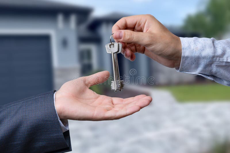 A Hand Giving a Key To Another Hand. House in the Background. Stock ...