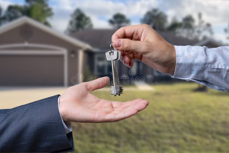 A Hand Giving a Key To Another Hand. House in the Background. Stock ...