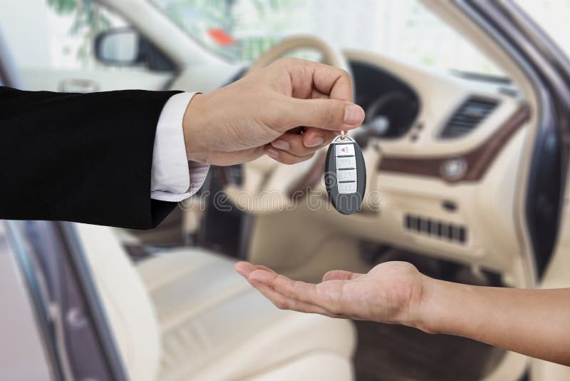 Hand Giving and Receiving Car Key Remote, with Modern Car Background ...