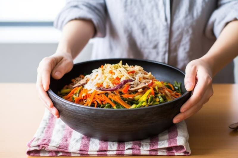 Hand Grabbing Stone Bowl of Bibimbap Using Oven Mitt Stock Photo ...