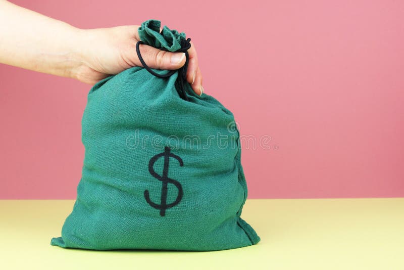A Hand a Green Money Bag stock image. Image of hand - 196081525