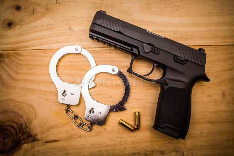 Hand Gun With Hand Cuffs On Wooden Surface Stock Image - Image of ...