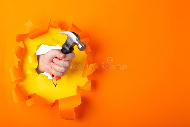 Hand with Hammer through a Torn Orange Paper Stock Photo - Image of ...