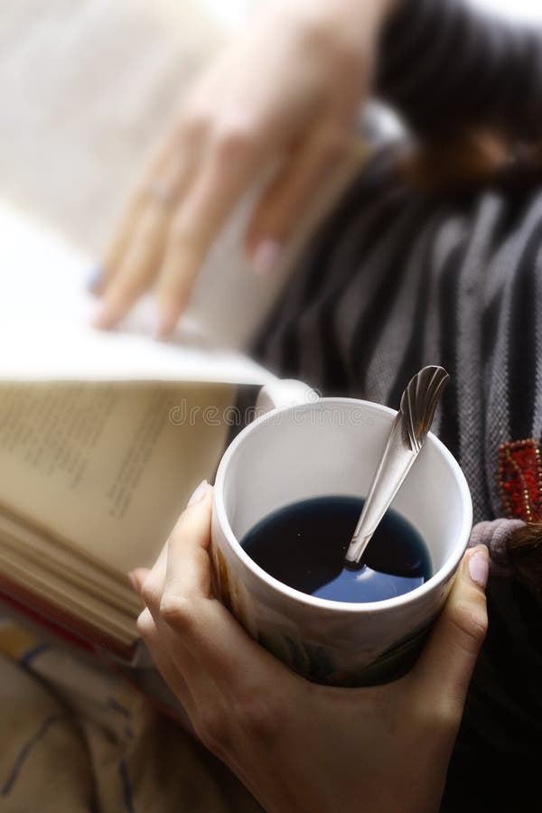 Hand Hold Cup with Blue Tea with Teaspoon and Book Stock Image - Image ...