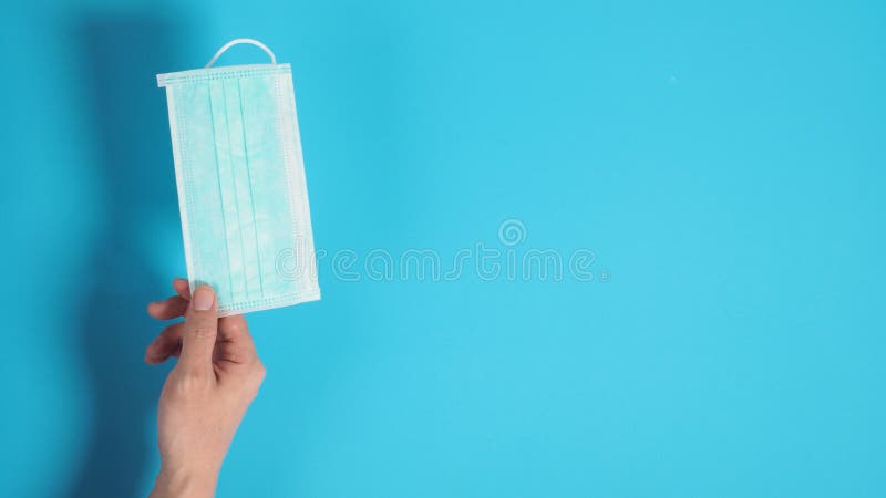 Hand is Hold Face Mask or Medical Mask Isolated on Blue Background ...