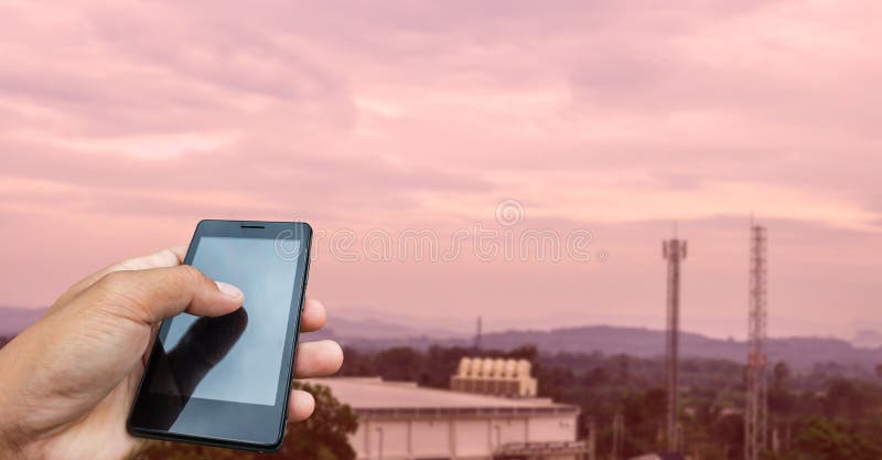 Hand Hold and Touch Screen Smart Phone, on Blur Image of Factory ...