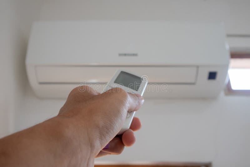 Hand Holding Ac Remote Control Directed Air Conditioner Inside Room ...