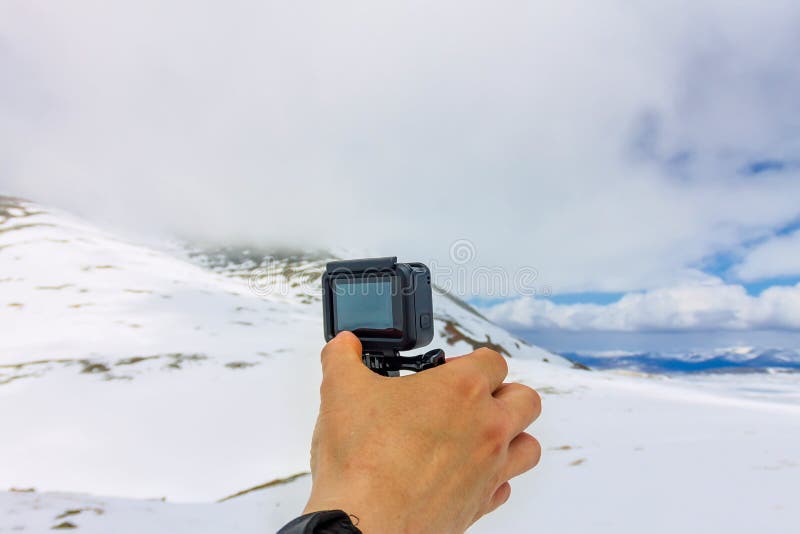 Hand Holding Action Camera Action Camera Stands on a Tripod Against the ...