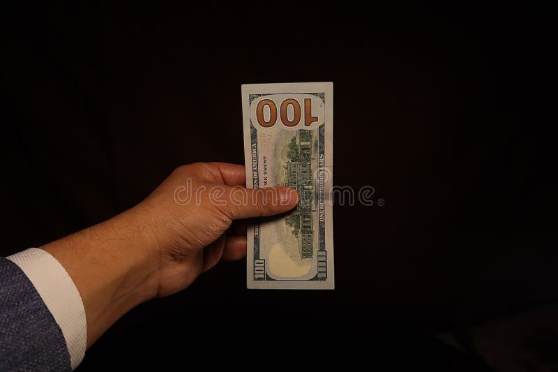 Hand Holding Back Side of $100 U.S. Bill Isolated on Black Background ...