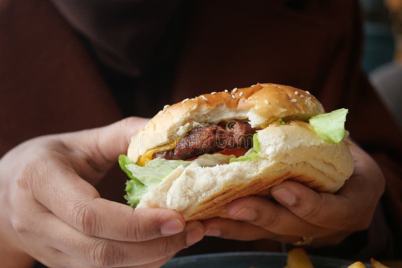 Hand Holding Beef Burger on Table Close Up Stock Image - Image of wood ...