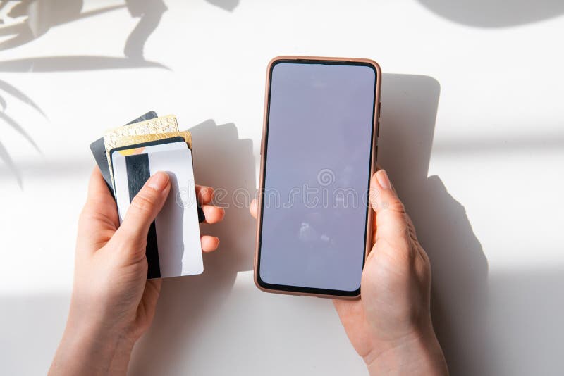 Hand Holding Bench of Credit Cards and Phone with White Screen Stock ...