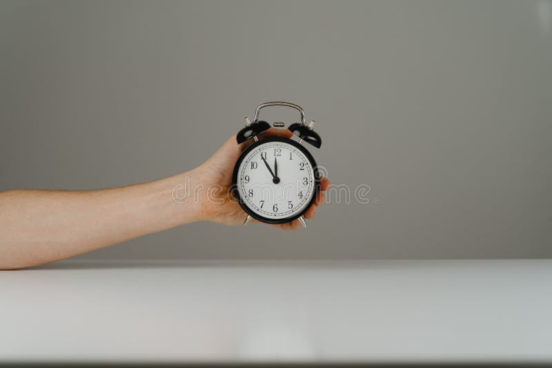 Hand Holding Black Alarm Clock Stock Photo - Image of office, black ...