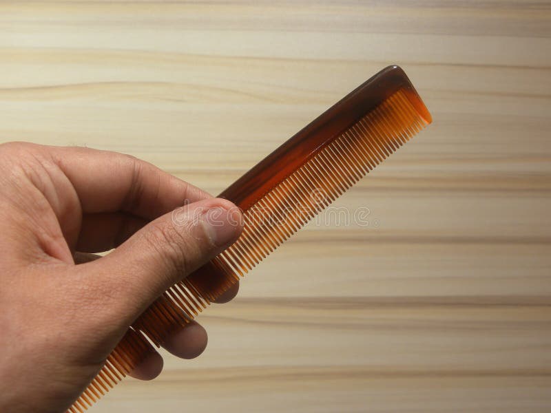 Hand holding brown comb stock photo. Image of hairdressing - 166492518