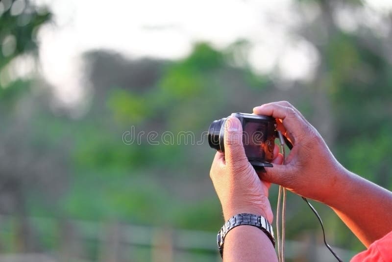 Hand Holding Camera Photograph in Nature Background Stock Image - Image ...