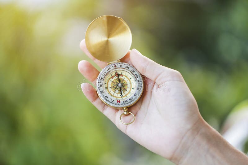 Hand Holding a Compass in Nature Stock Photo - Image of hand, arrow ...